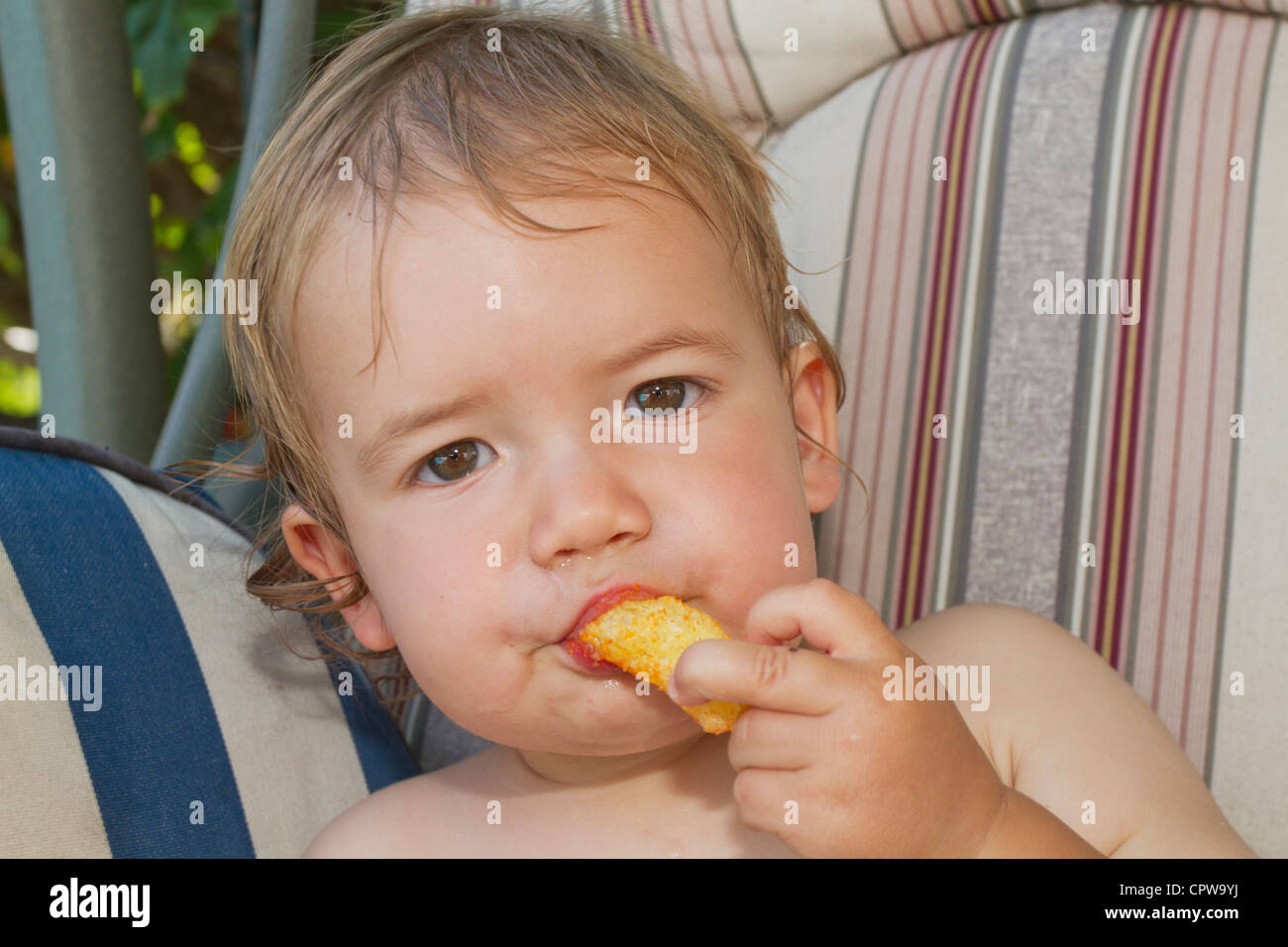 Ben eating a crisp at 14 months by the pool Stock Photo - Alamy