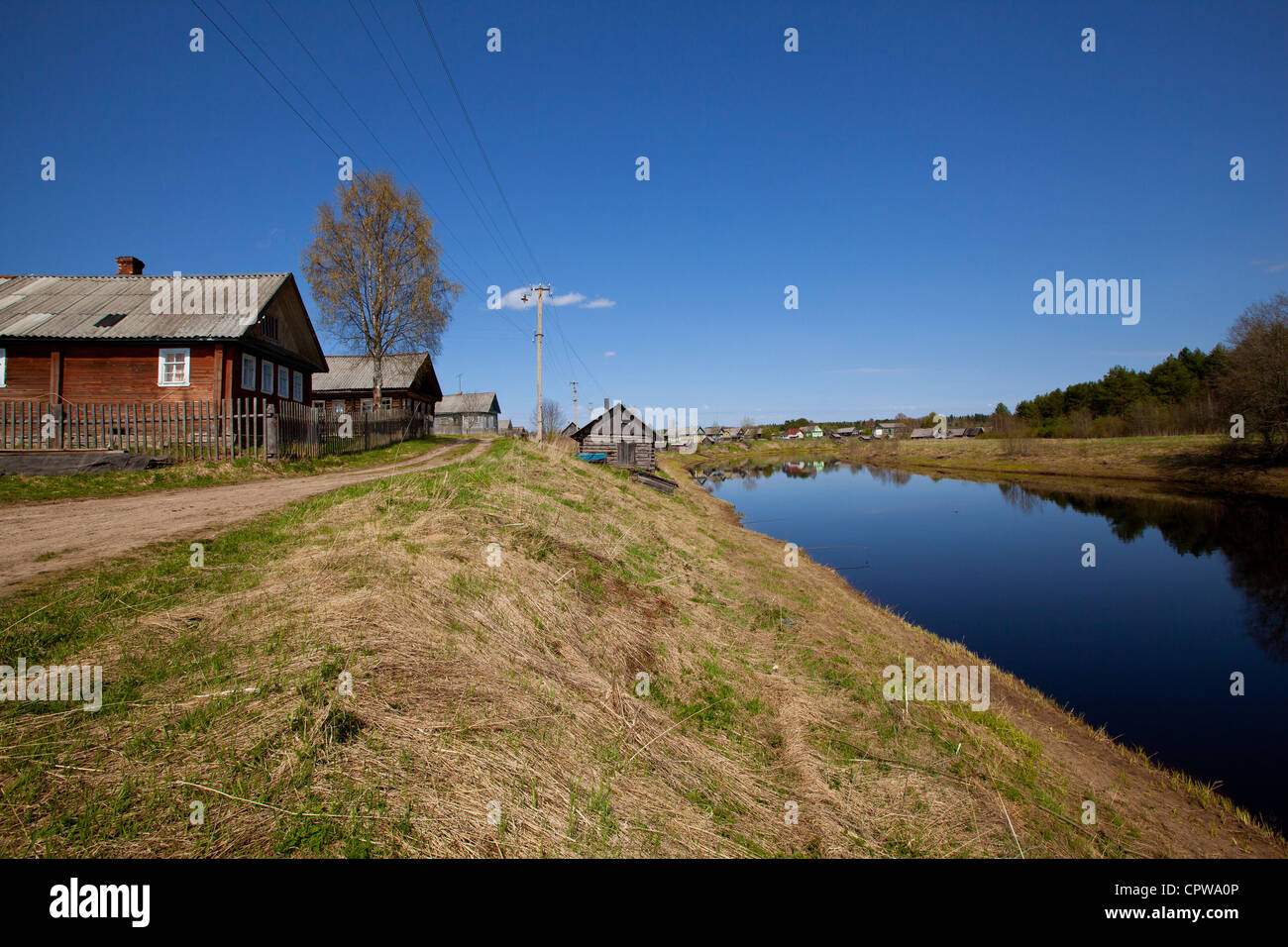 Typical small village near the river in the rays of spring sunshine, in ...