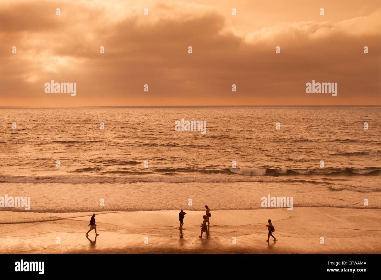 People on the beach at sunset Stock Photo - Alamy