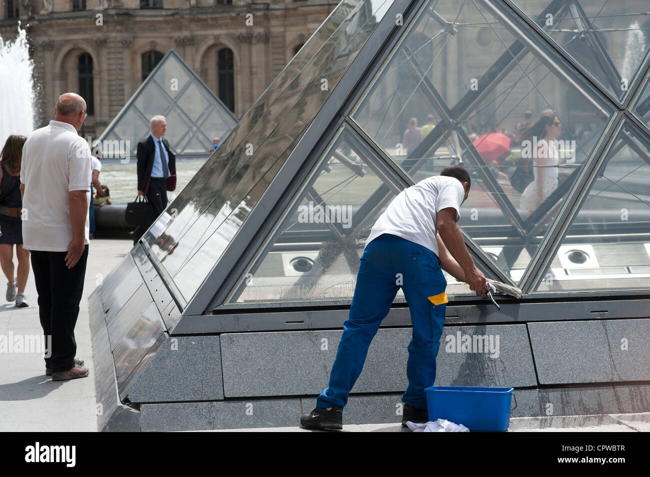 Paris, France - A worker cleaning the pyramid of the Louvre Museum ...