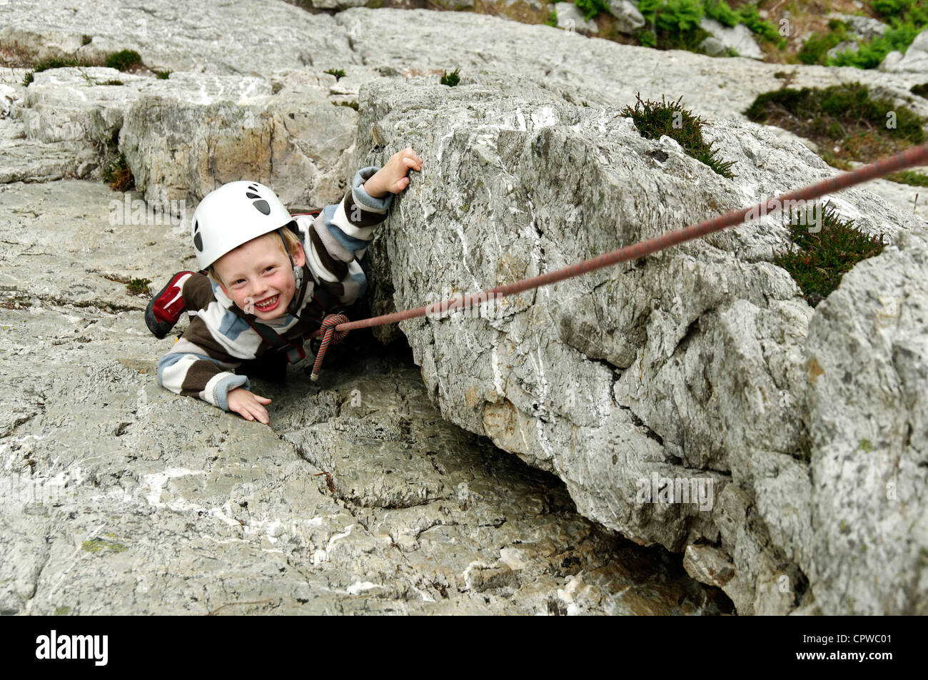 A young boy rock climbing on Anglesey Stock Photo - Alamy