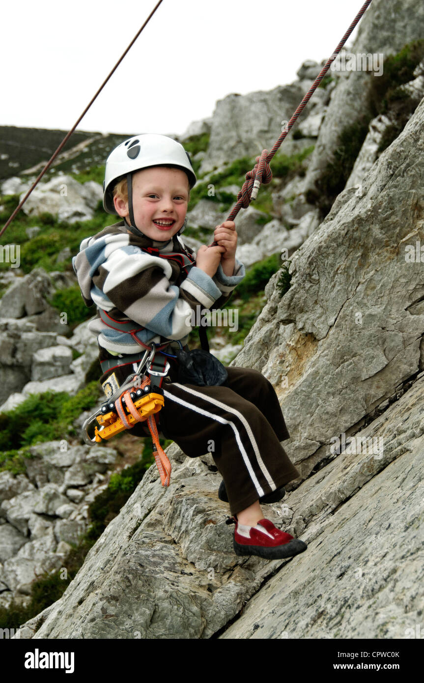 A young boy rock climbing on Anglesey Stock Photo - Alamy