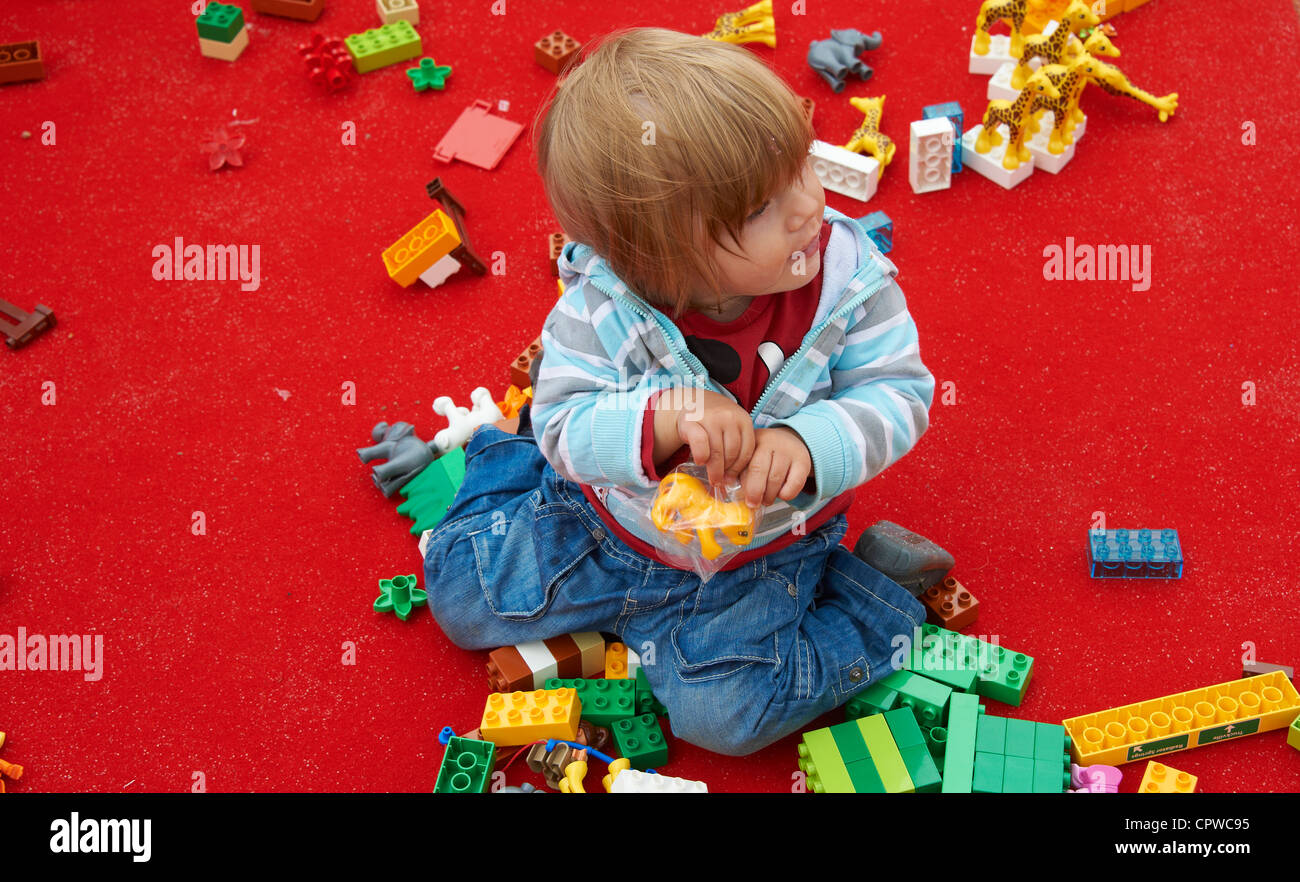 Little Baby Child Girl Playing With Building Blocks on Red Carpet Stock ...