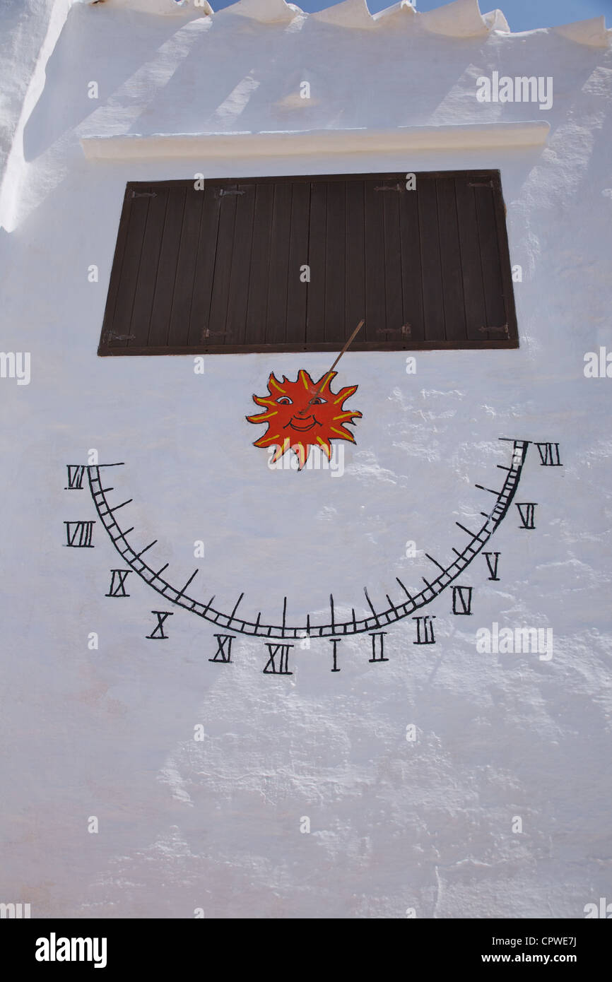 red and yellow sundial painted on white wall Stock Photo - Alamy