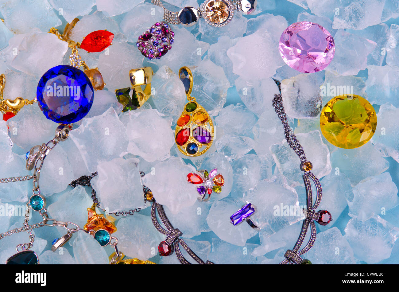 Jewels at blue cube of ice background Stock Photo - Alamy