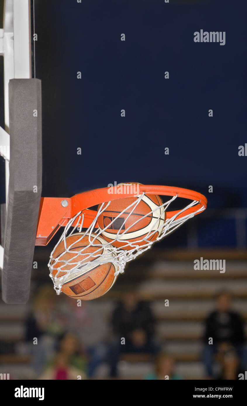 Two basketballs in the hoop indoors Stock Photo - Alamy
