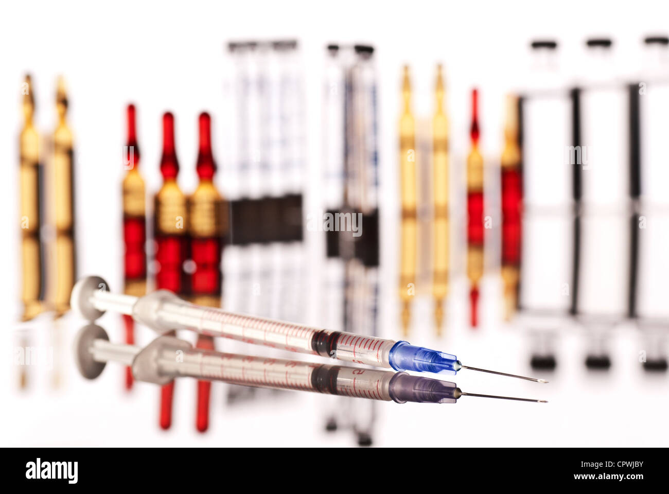 A disposable syringe in front of a large group of flasks with injection ...
