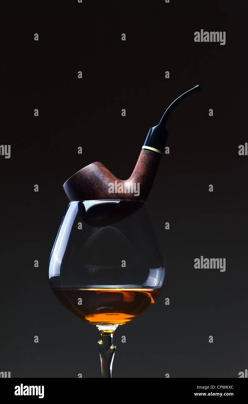 cognac and pipe on a dark background Stock Photo - Alamy