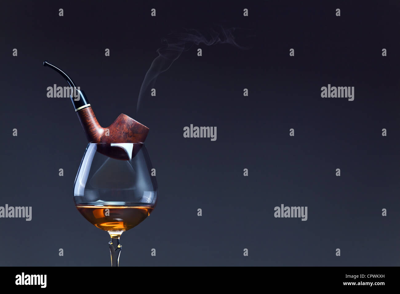 cognac and pipe on a dark background Stock Photo - Alamy