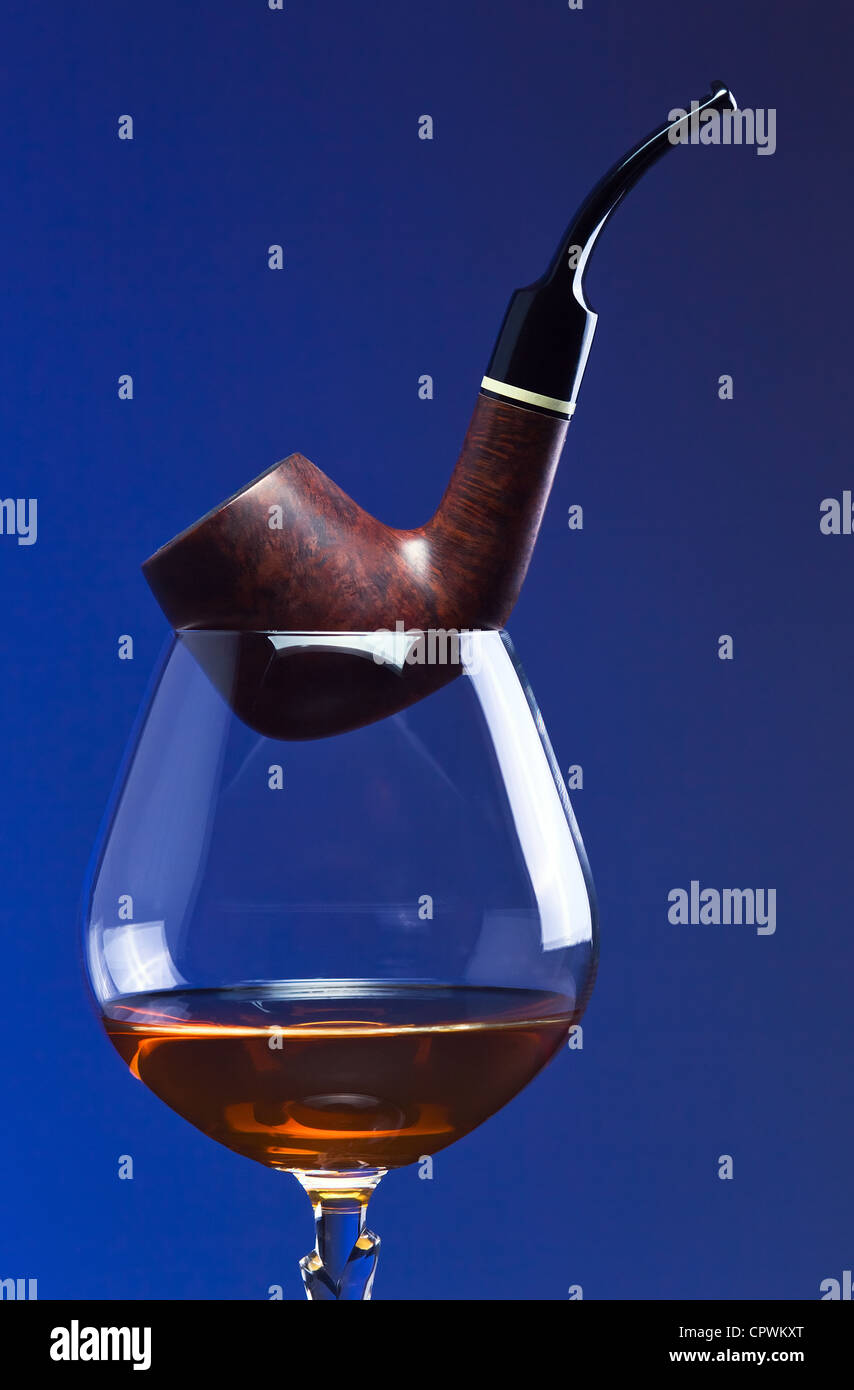 cognac and pipe on a dark blue background Stock Photo - Alamy