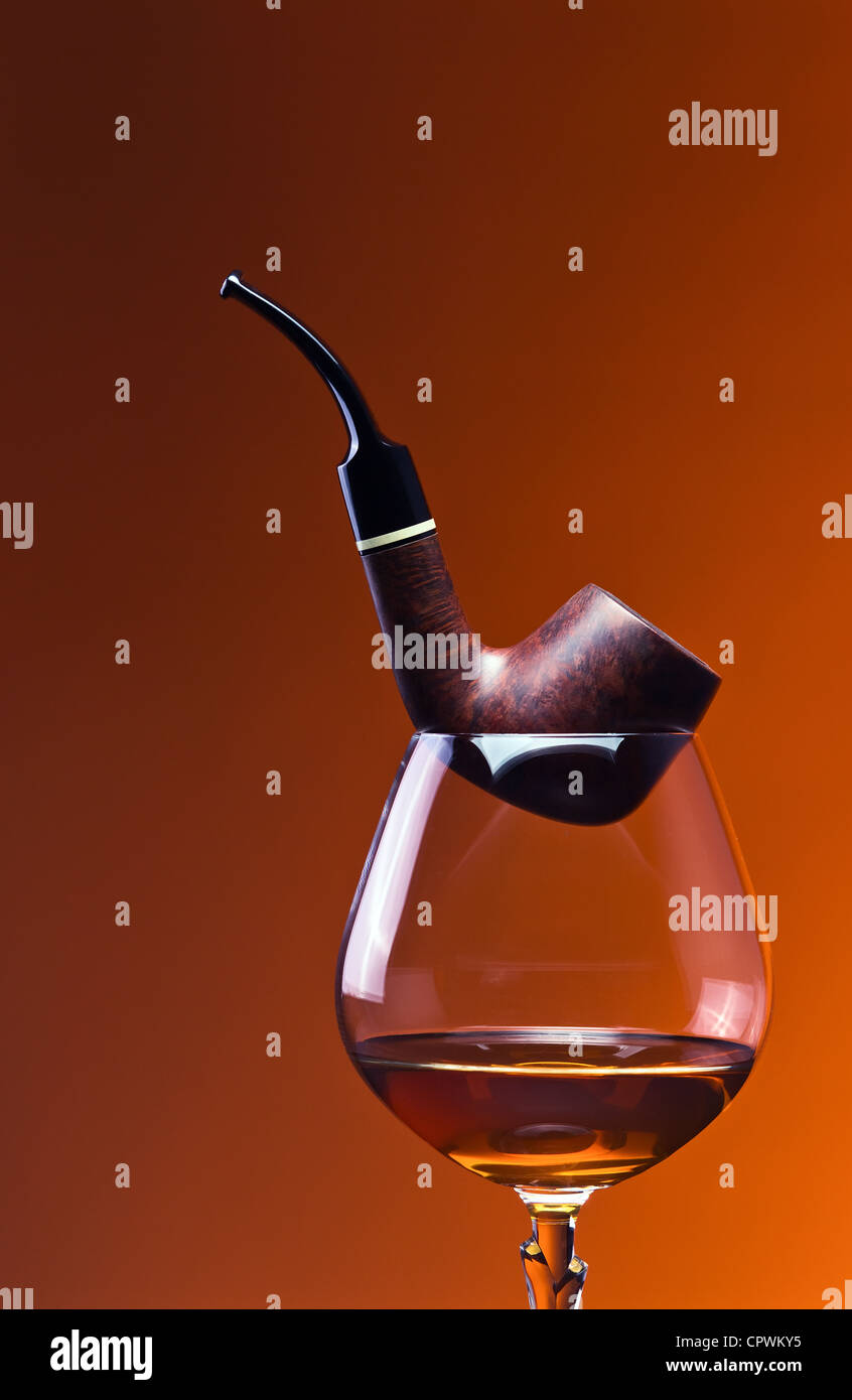 cognac and pipe on a dark background Stock Photo - Alamy