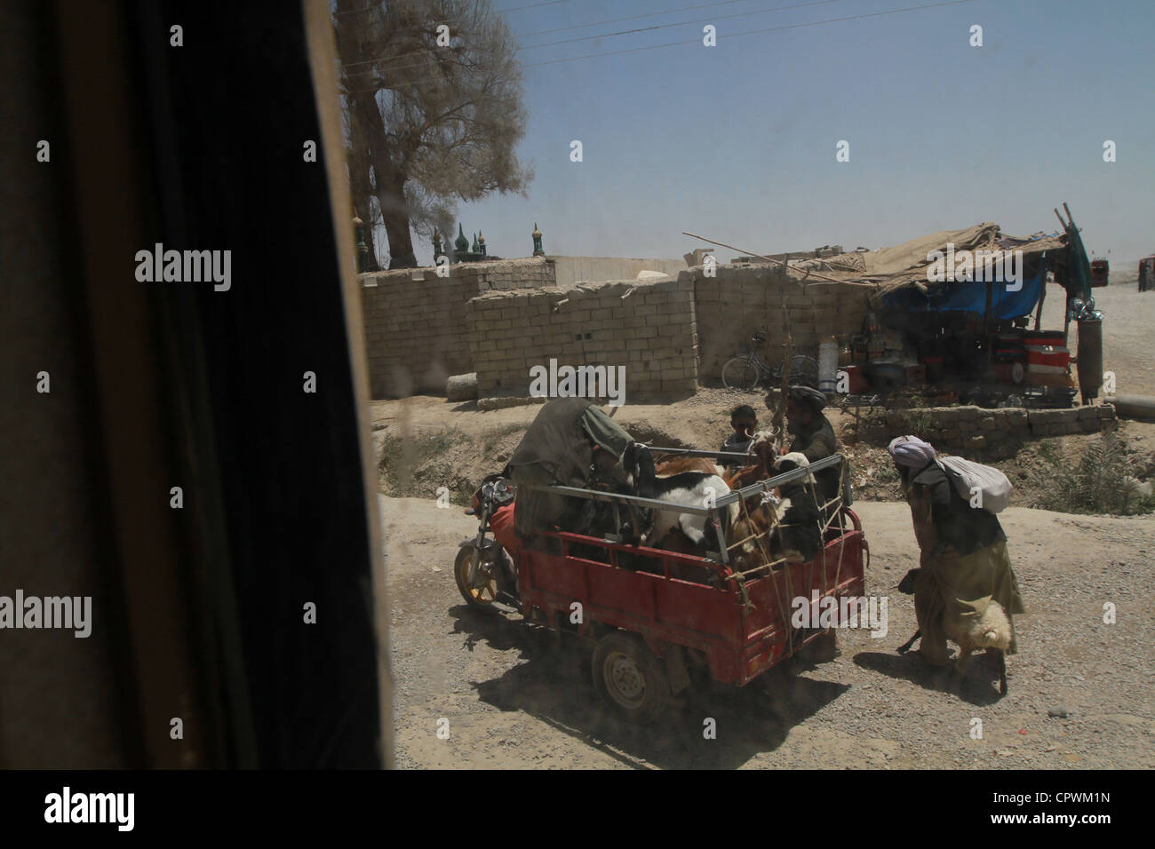 An Afghan man leads a goat toward a trailer in Lashkar Gah, Helmand ...