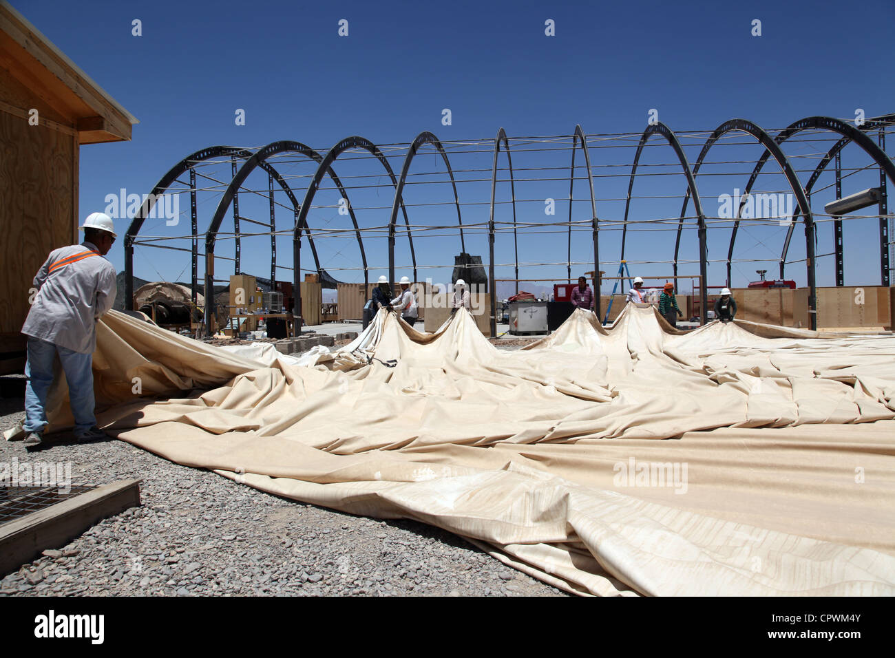 DynCorp International employees lay out the tarp used to cover the ...