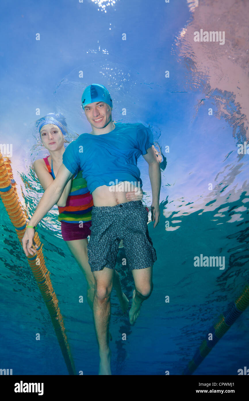 Happy smiling couple swimming together - underwater shoot from bellow ...