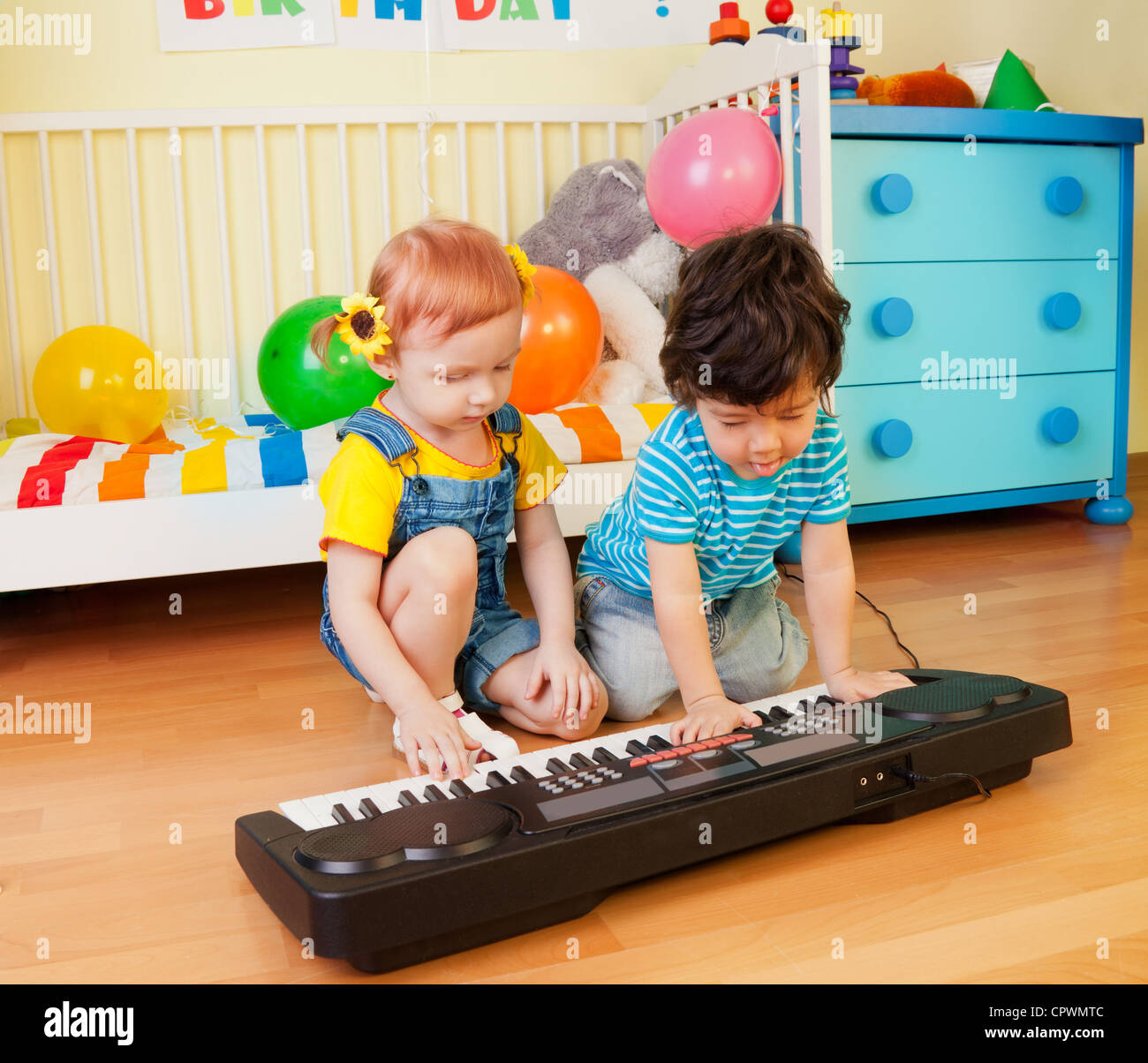 Happy little boy and girl playing a musical instrument Stock Photo - Alamy