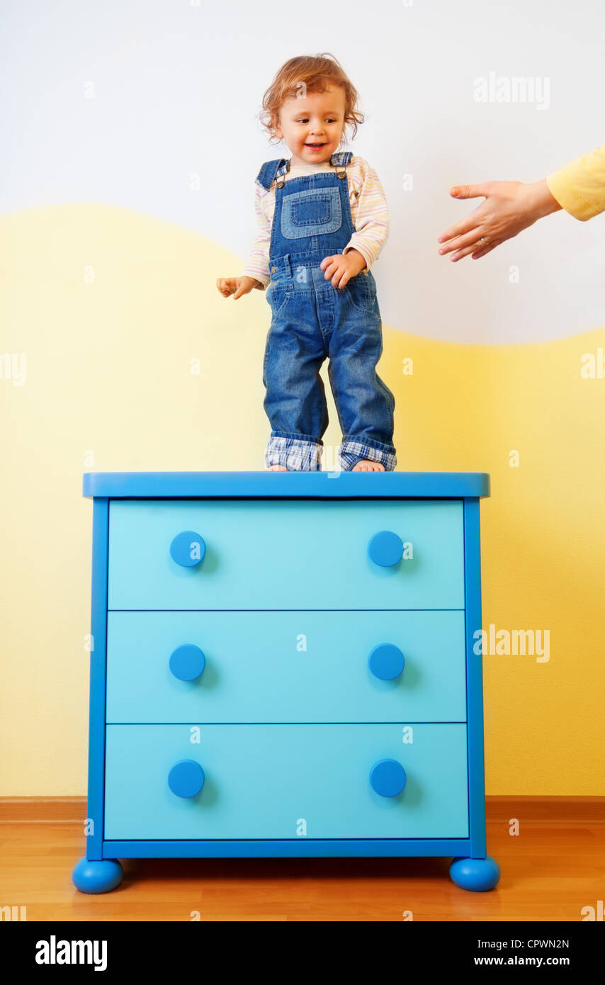 Kid jumping from the cabinet on the floor Stock Photo - Alamy