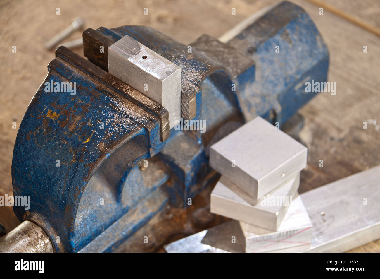 Vice with a block of metal on a wooden workbench Stock Photo - Alamy