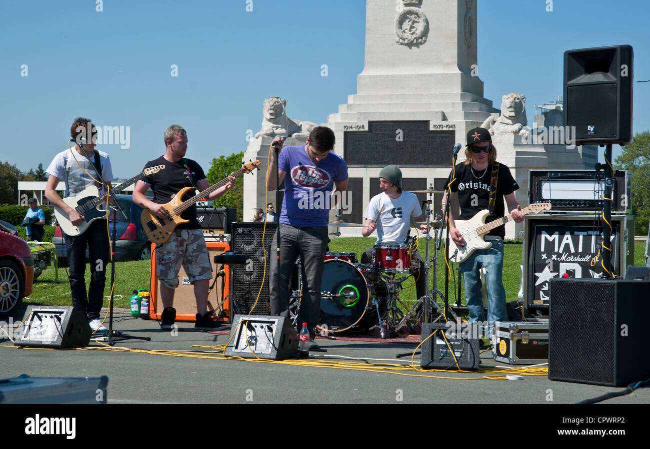 A small band playing their music on Plymouth Hoe, with guitars and ...