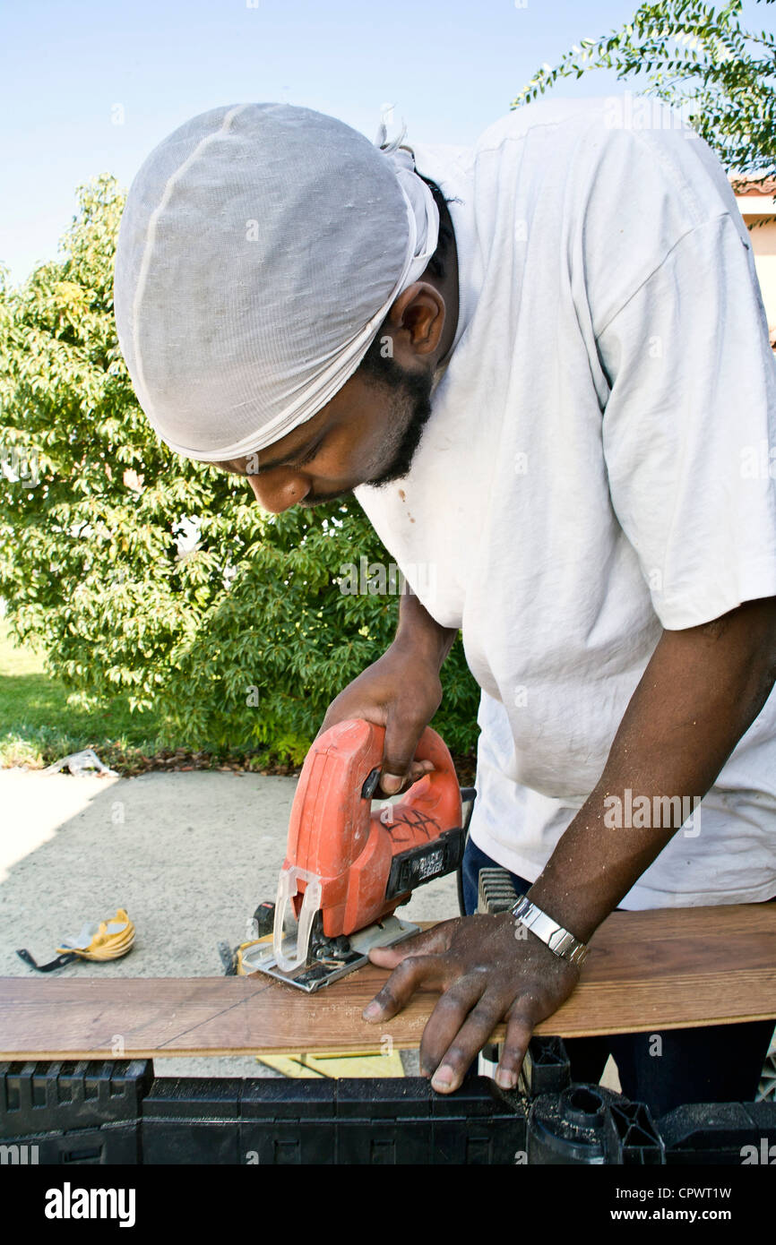 Skilled carpenter cutting wood installing wood floor. MR © Myrleen ...