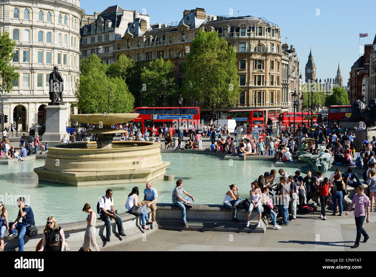 Crowds and red London buses at Trafalgar Square, London with Big Ben in ...
