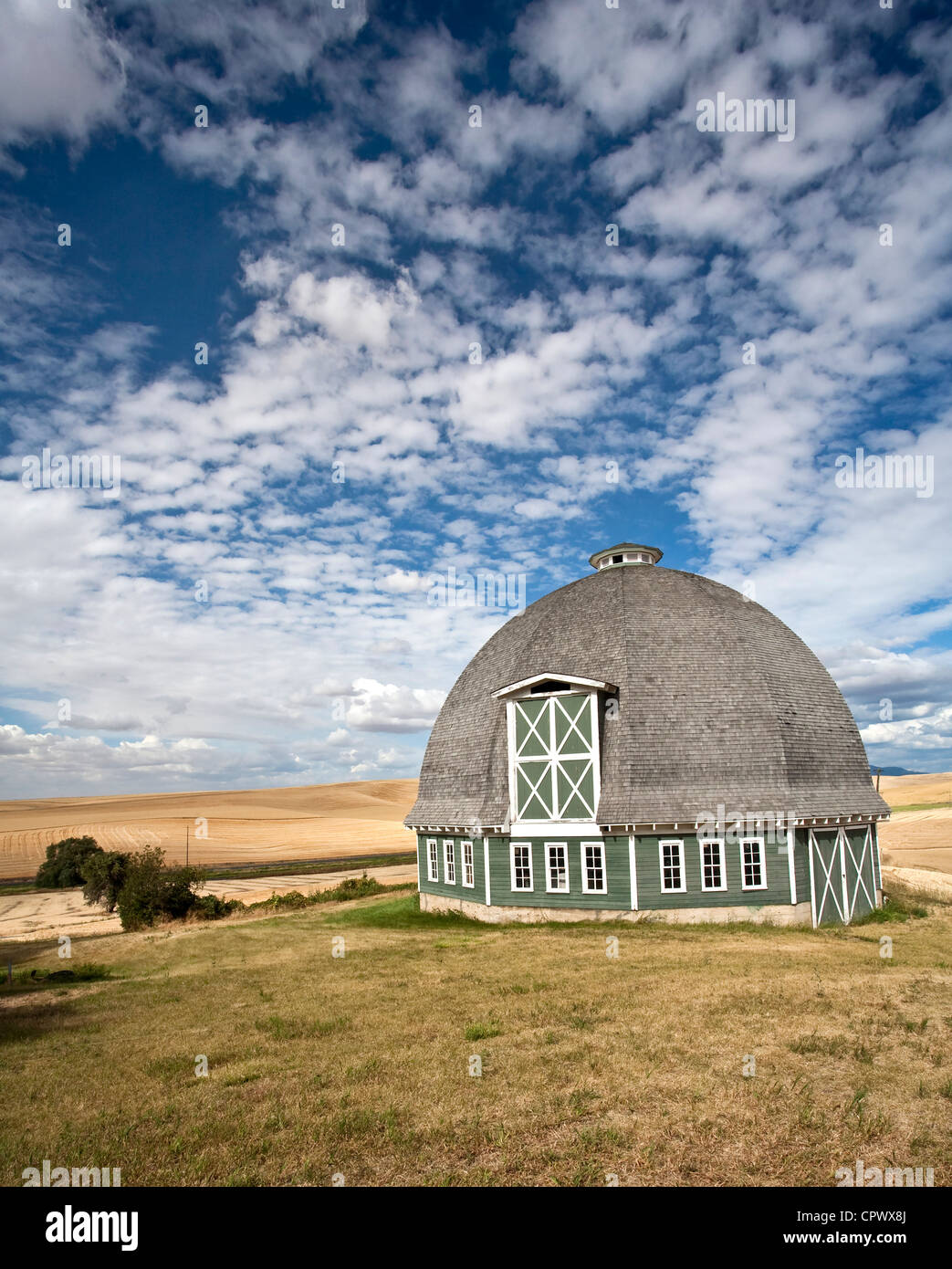 A scenic view of a round barn with a blue sky in the background Stock ...
