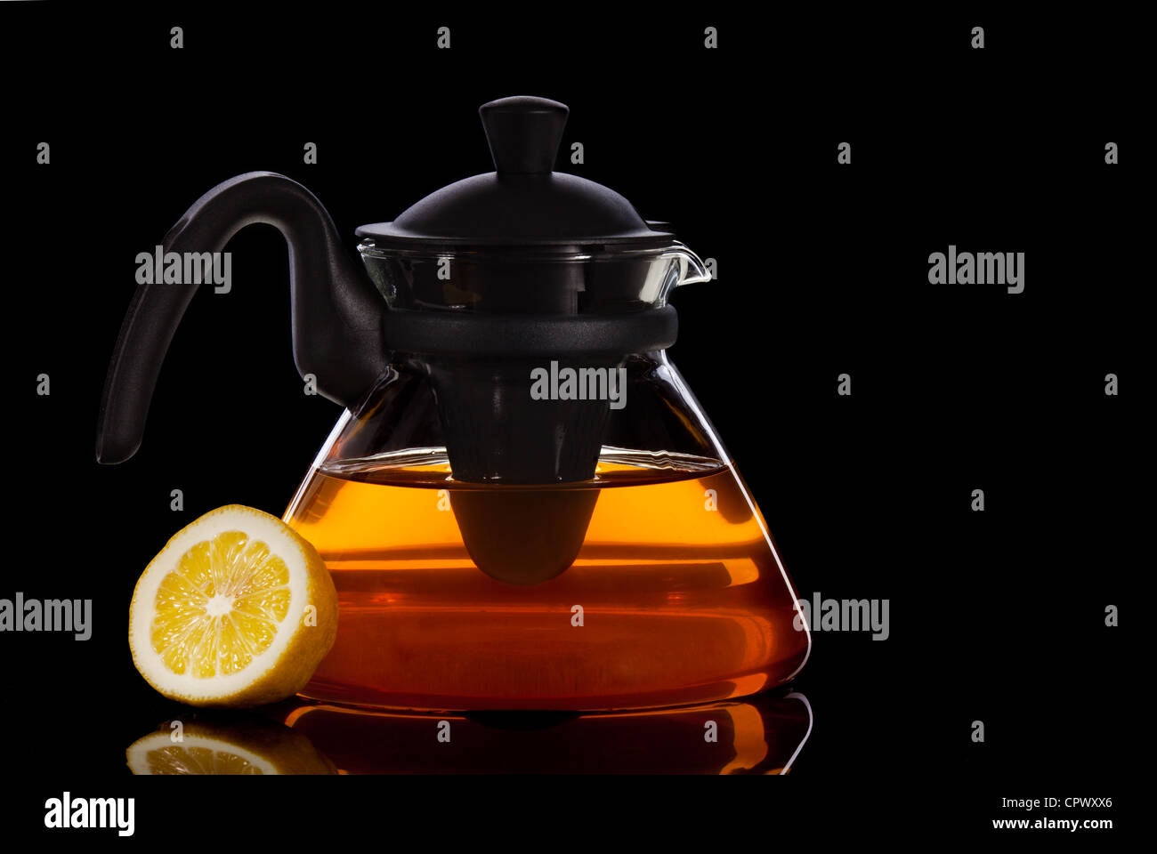 Tea in transparent glass pot with lemon on dark background Stock Photo ...