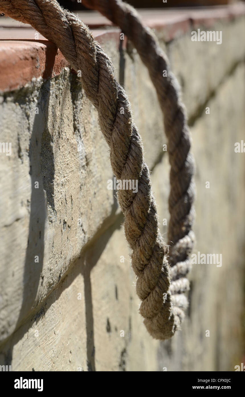 Rope hanging from a wall Stock Photo - Alamy