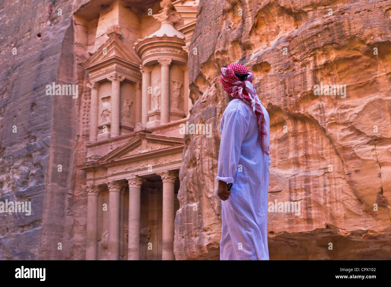 Arab man watching Facade of Treasury (Al Khazneh), Petra, Jordan ...