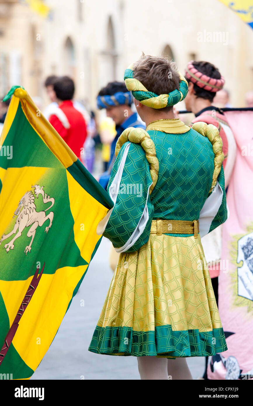 Contrada young men in livery costumes at traditional parade in Asciano ...