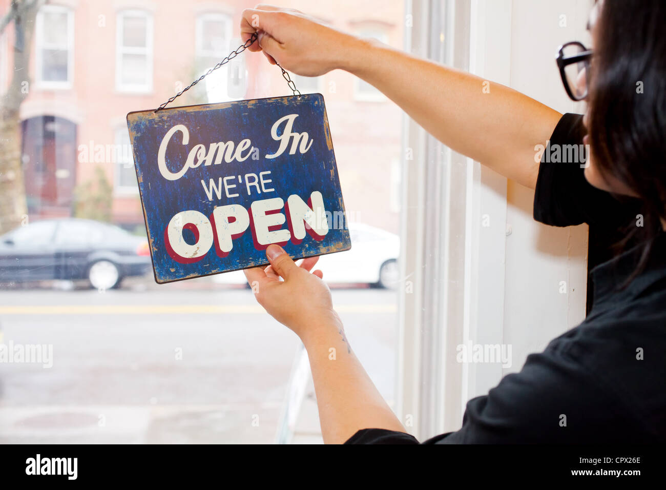 Man flipping over open sign in cafe Stock Photo - Alamy