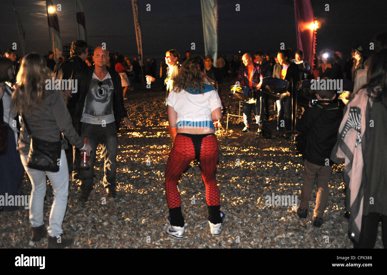 Crowds dance on Brighton beach by the West Pier at the lighting of a ...
