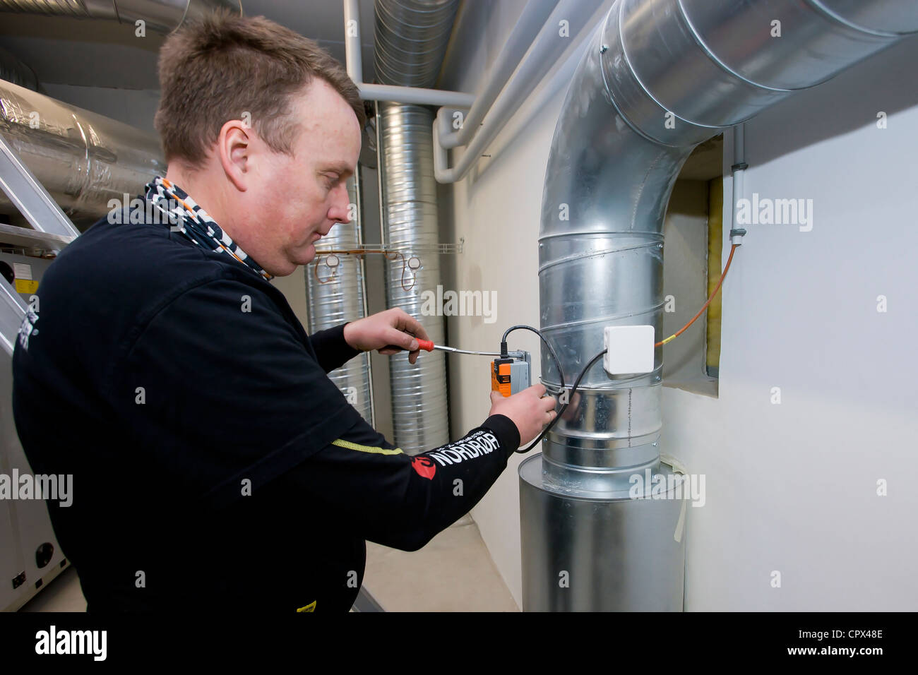 Heating and sanitary technician installs a temperature sensor Stock ...