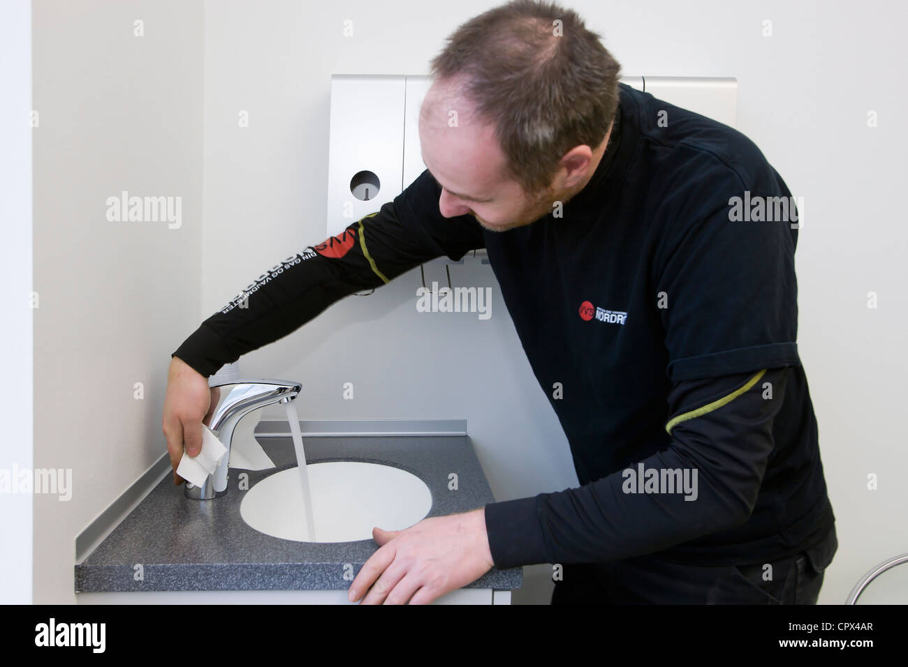Heating and sanitary technician cleaning a single lever mixer tap Stock ...