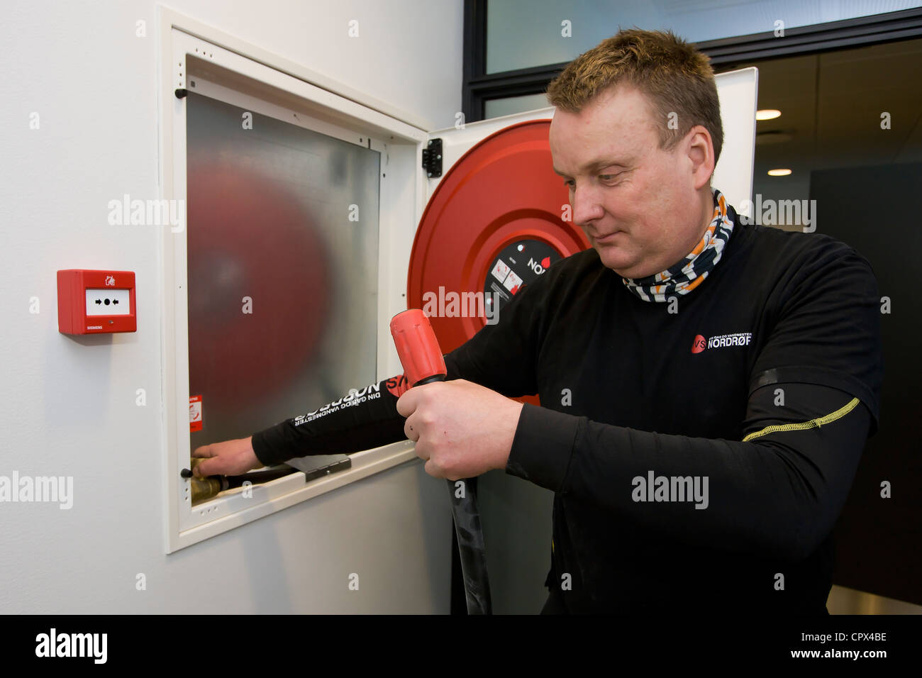 Heating and sanitary technician testing a fire hose Stock Photo - Alamy