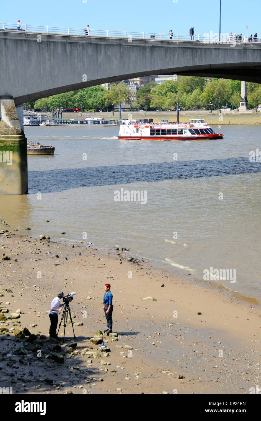 Making a video recording on River Thames foreshore below Waterloo ...