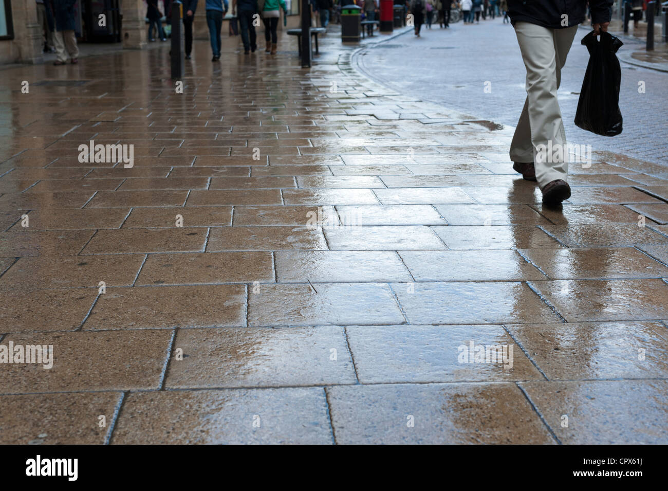 A wet pavement reflecting light on a raining day in Cambridge UK with ...