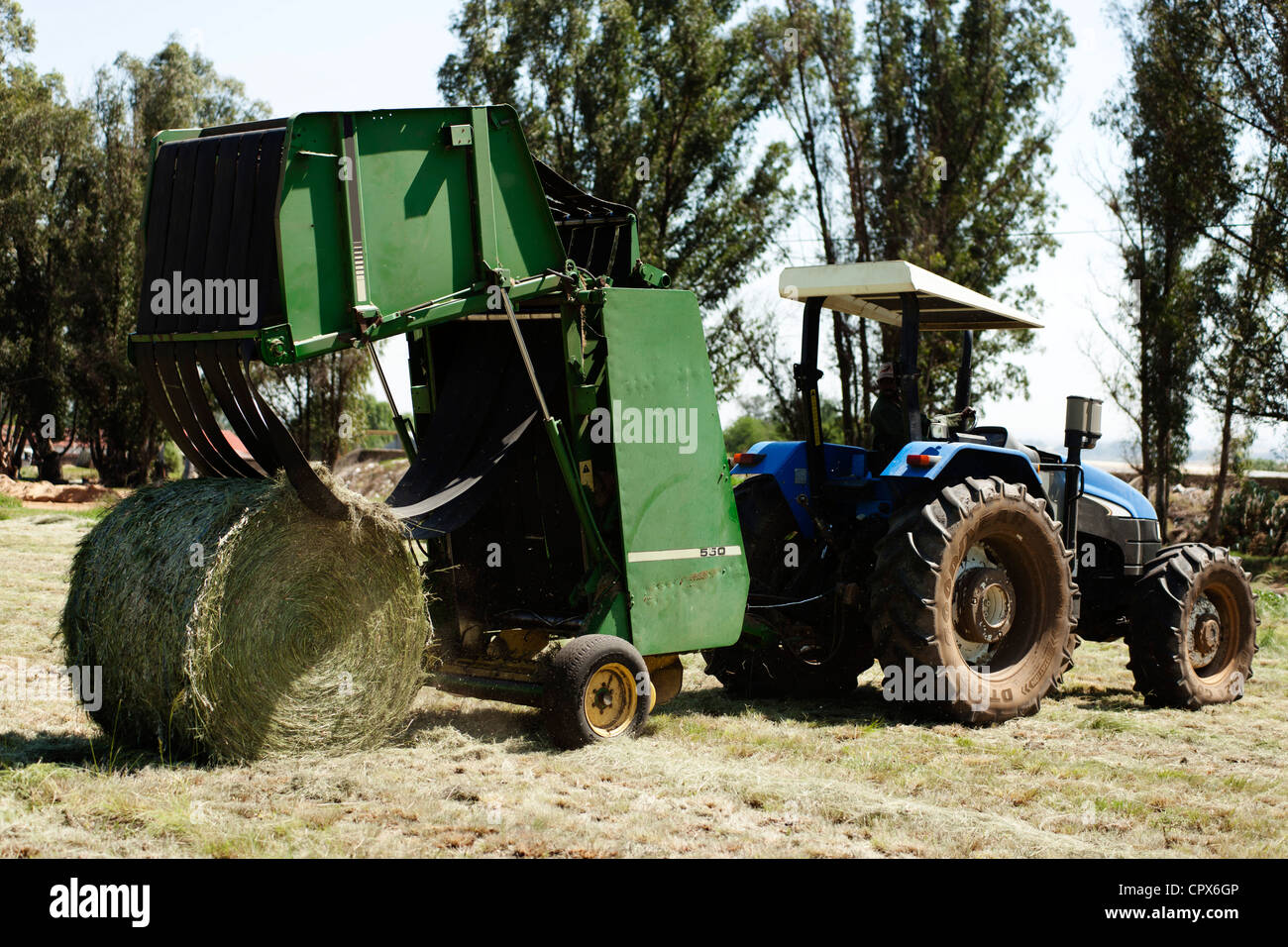 Farmworker driving plough tractor through field Stock Photo - Alamy