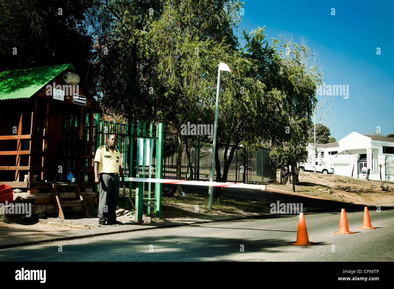 A security guard guarding a boom gate Stock Photo - Alamy