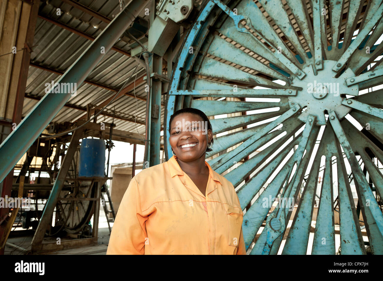 Female black factory worker stands in construction yard smiling at ...