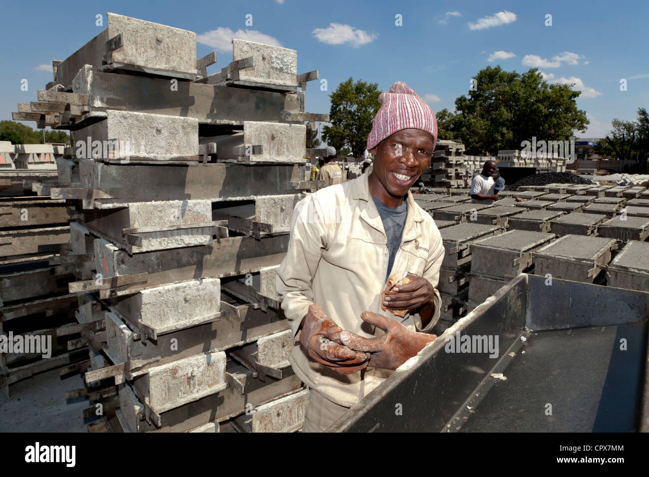 African construction worker standing in construction yard, smiling at ...