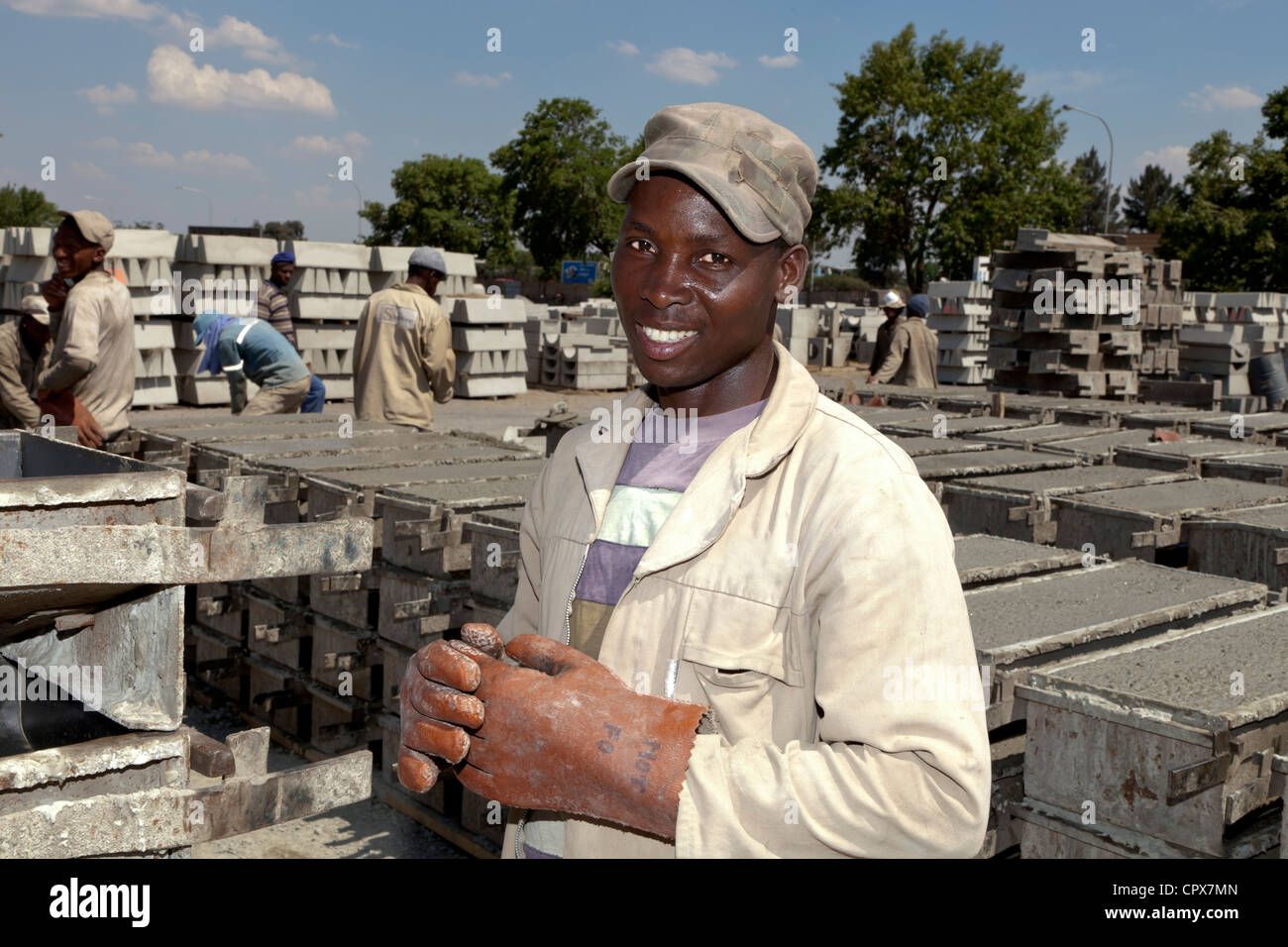 African construction worker standing in construction yard, smiling at ...