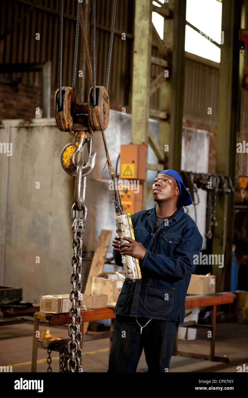 Factory worker operating block and tackle, magnet factory, Gauteng ...