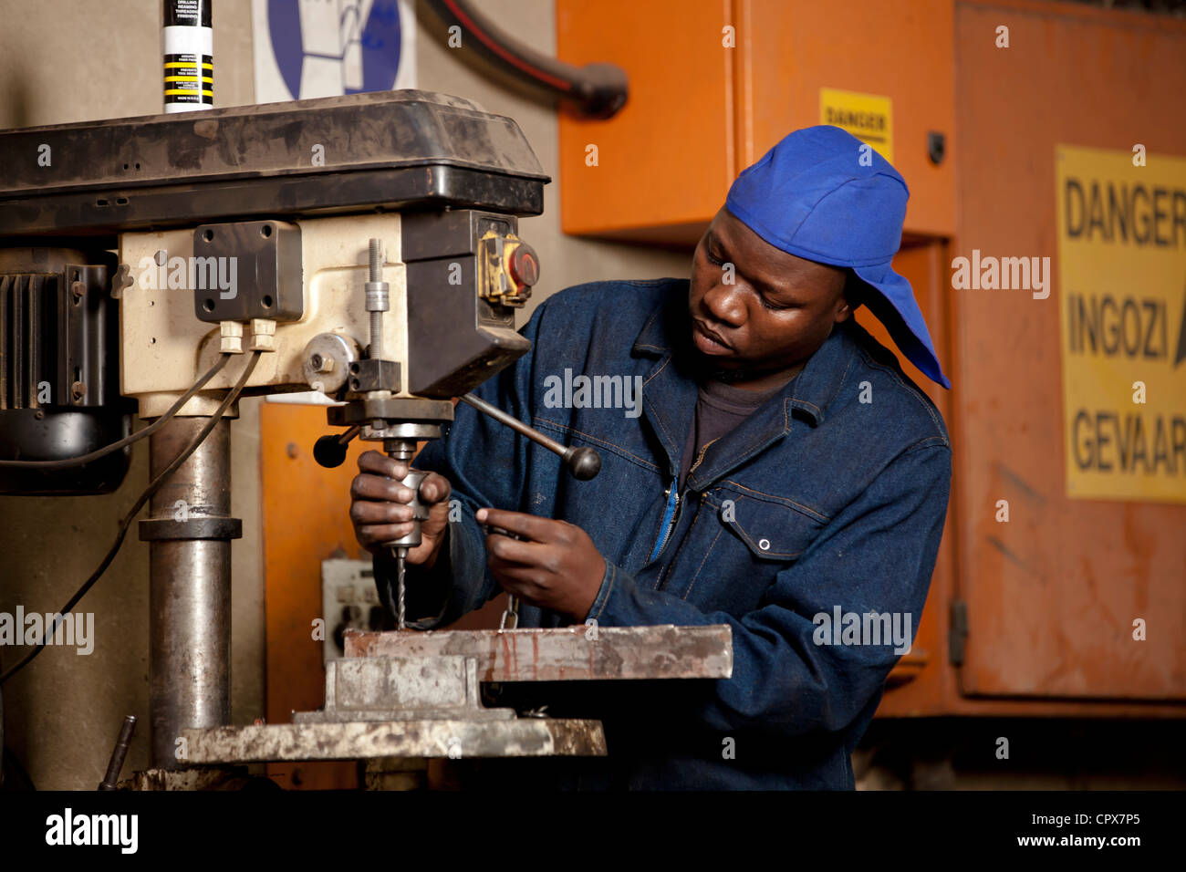 Factory worker operating drill press in magnet factory, Gauteng, South ...