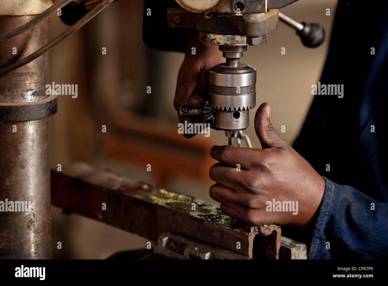 Factory worker operating drill press in magnet factory, Gauteng, South ...