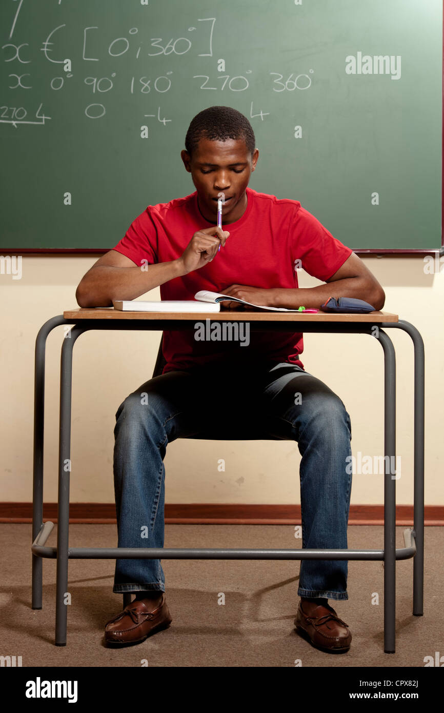 Male student working at a desk Stock Photo - Alamy