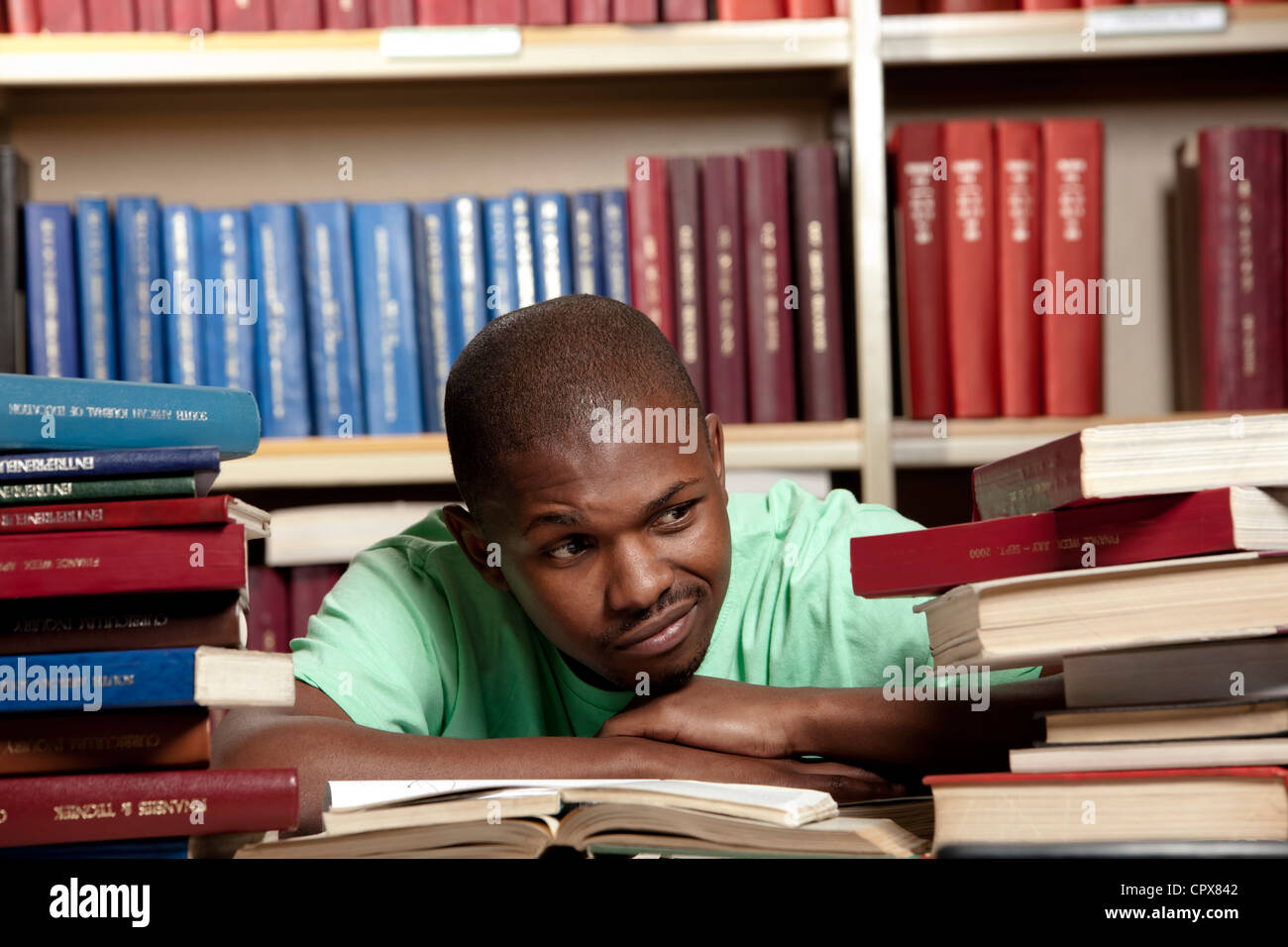 Male student studying with lots of books Stock Photo - Alamy