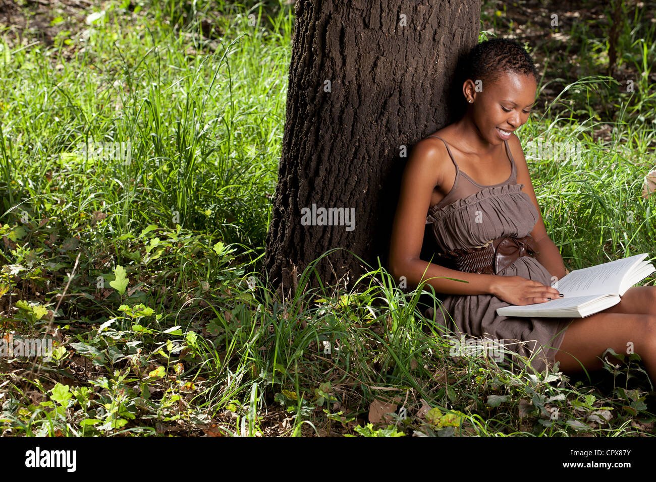 Girl Sitting Against Tree