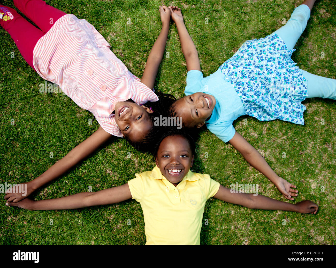Three children lay on the floor in a playground Stock Photo - Alamy
