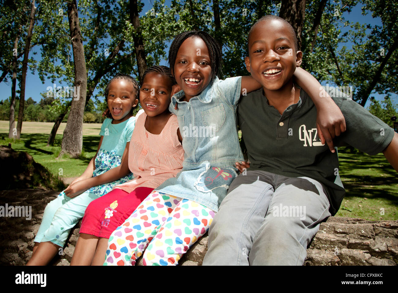 Children sitting on log in hi-res stock photography and images - Alamy