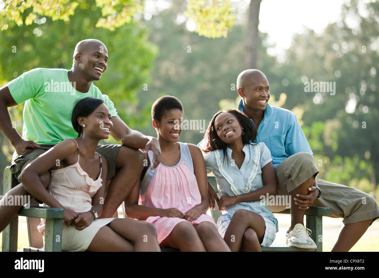 A group of young African friends sit together in a park Stock Photo - Alamy